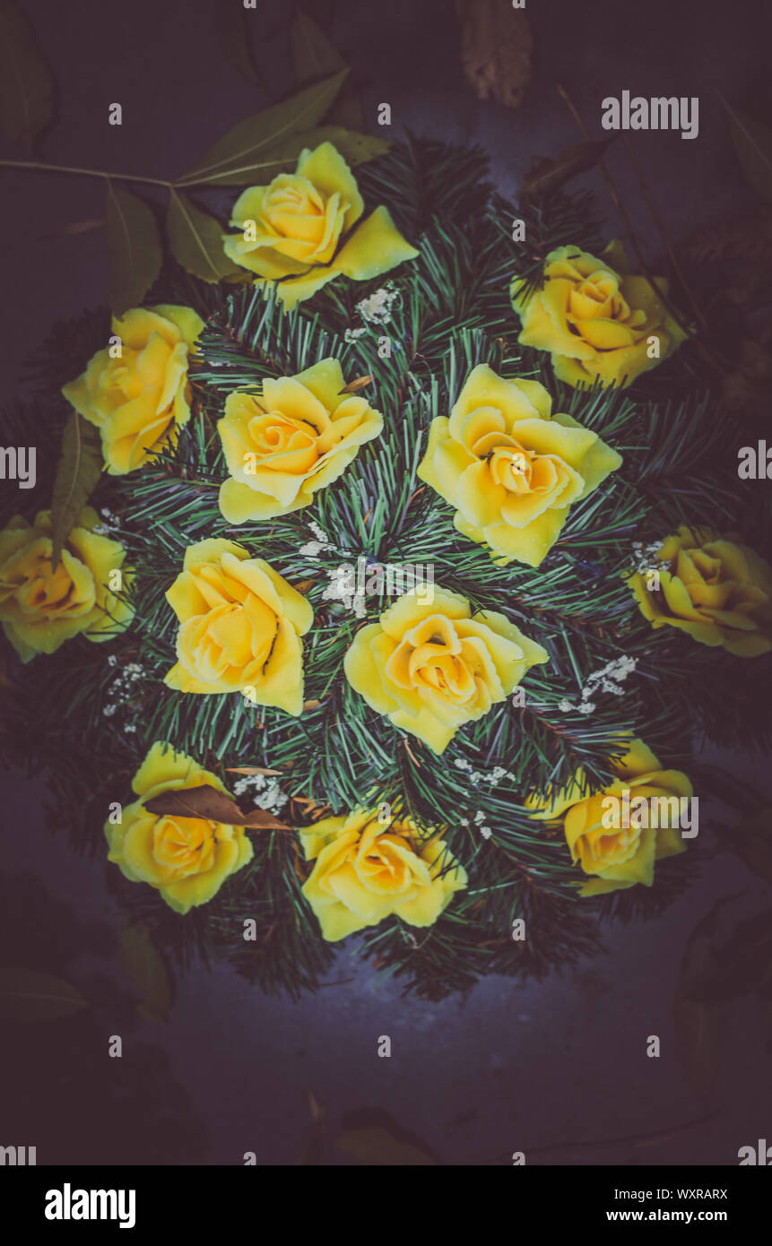 wreath of bright yellow roses in cemetery during religious christian ...