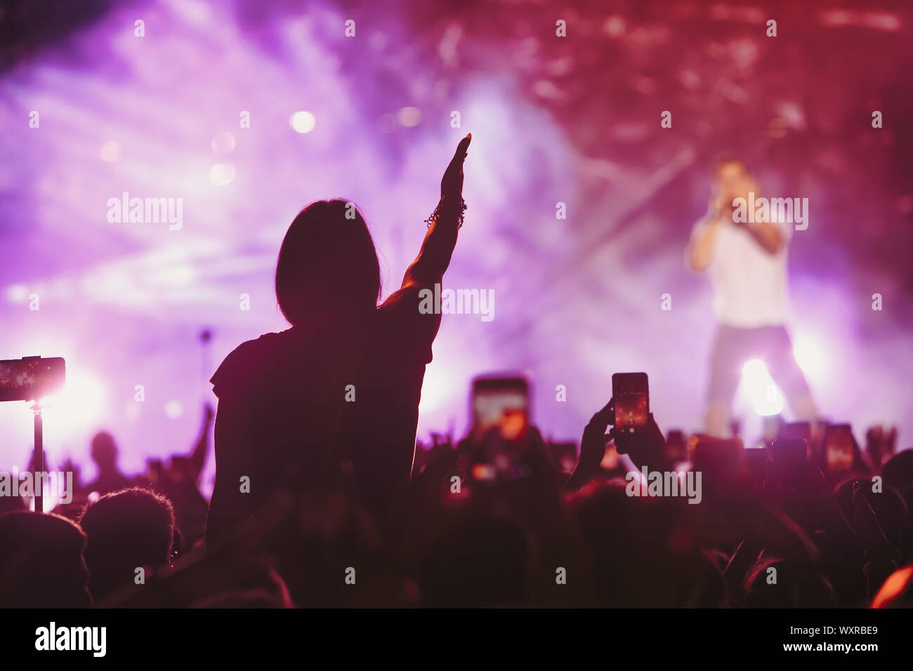 People taking photographs with touch smart phone during a music ...