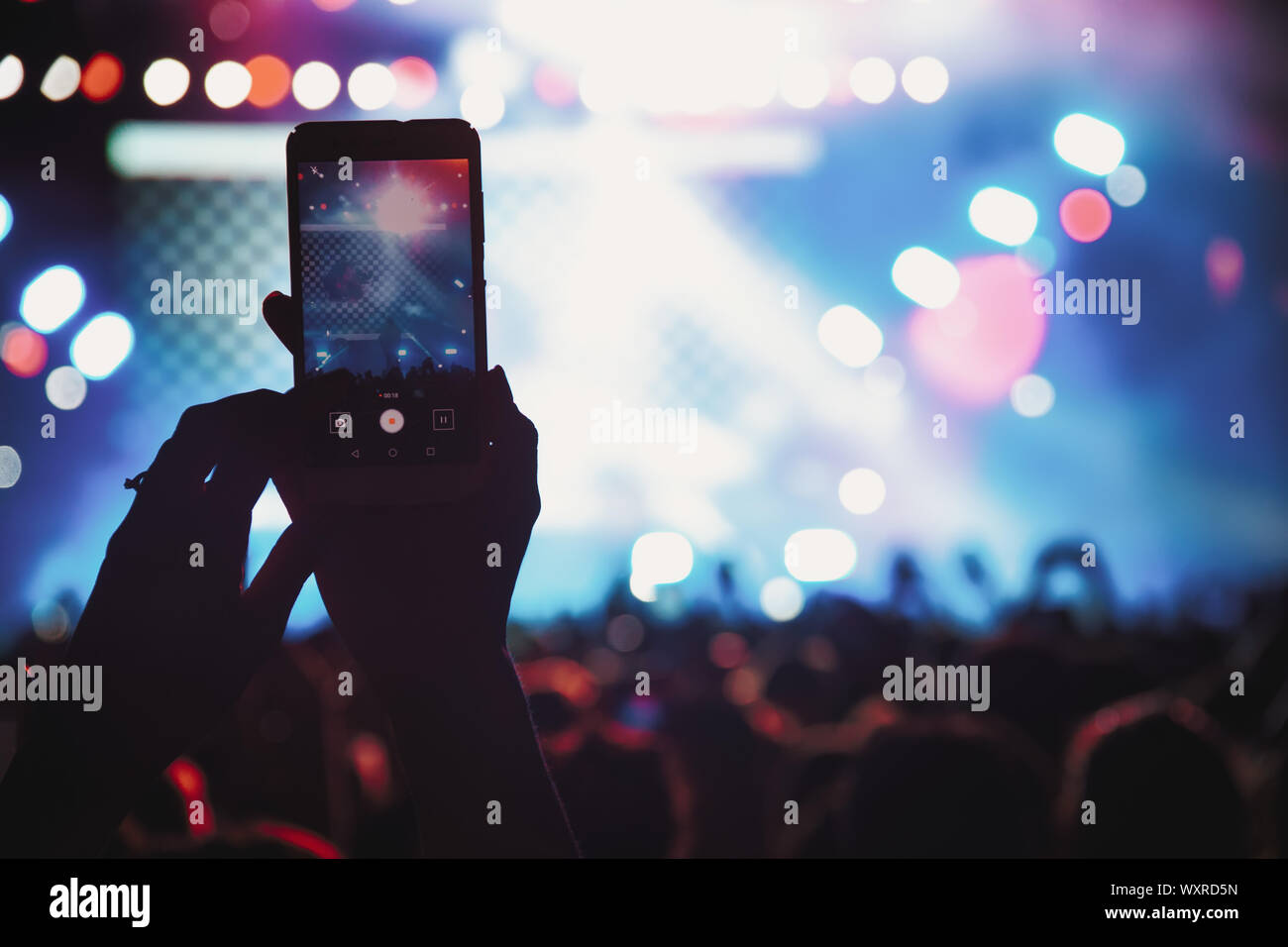 People taking photographs with touch smart phone during a music ...