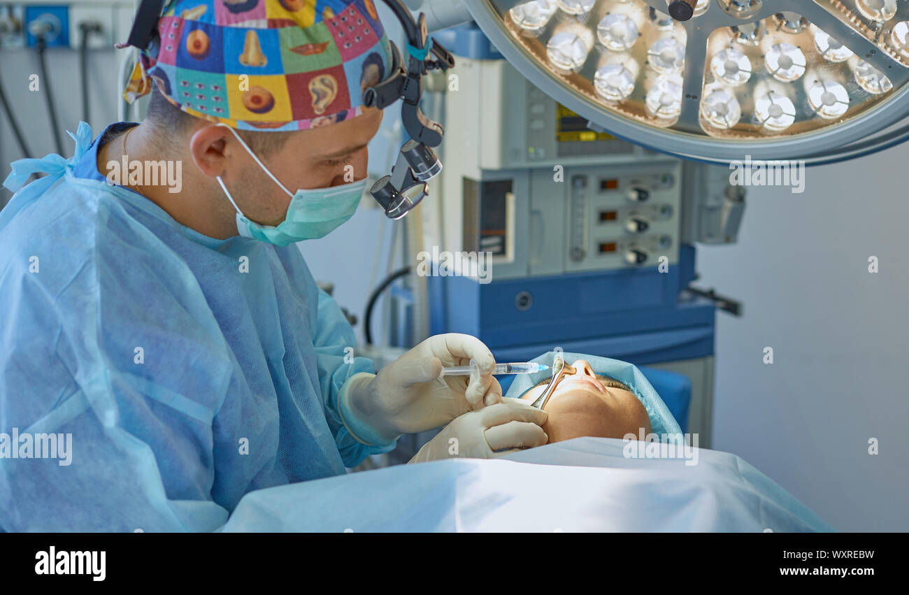 Several doctors surrounding patient on operation table during their ...