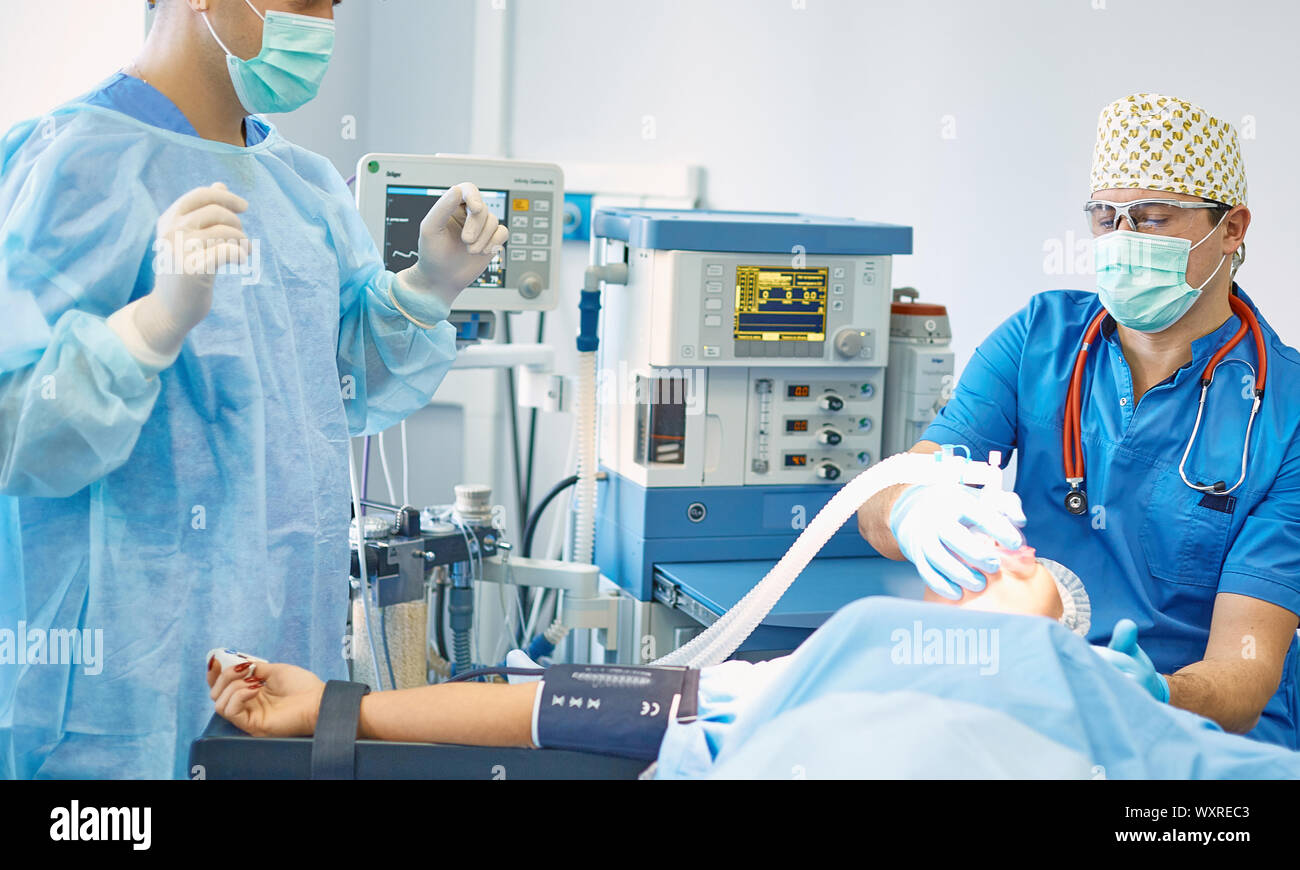 Several doctors surrounding patient on operation table during their ...