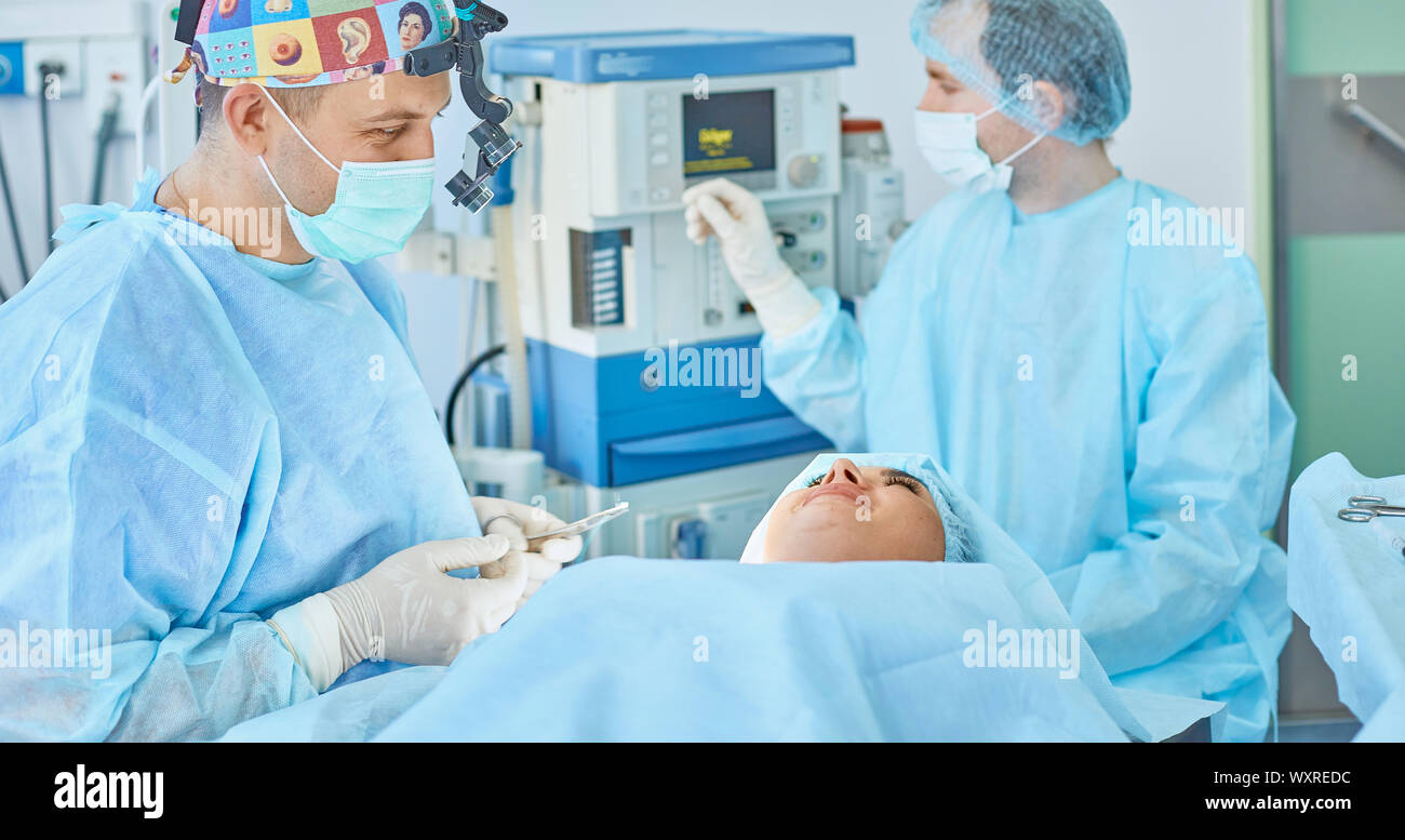 Several doctors surrounding patient on operation table during their ...