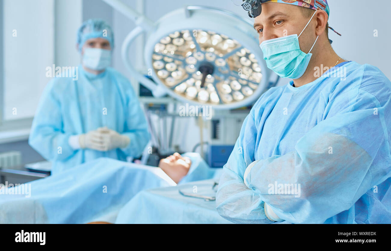 Several doctors surrounding patient on operation table during their ...