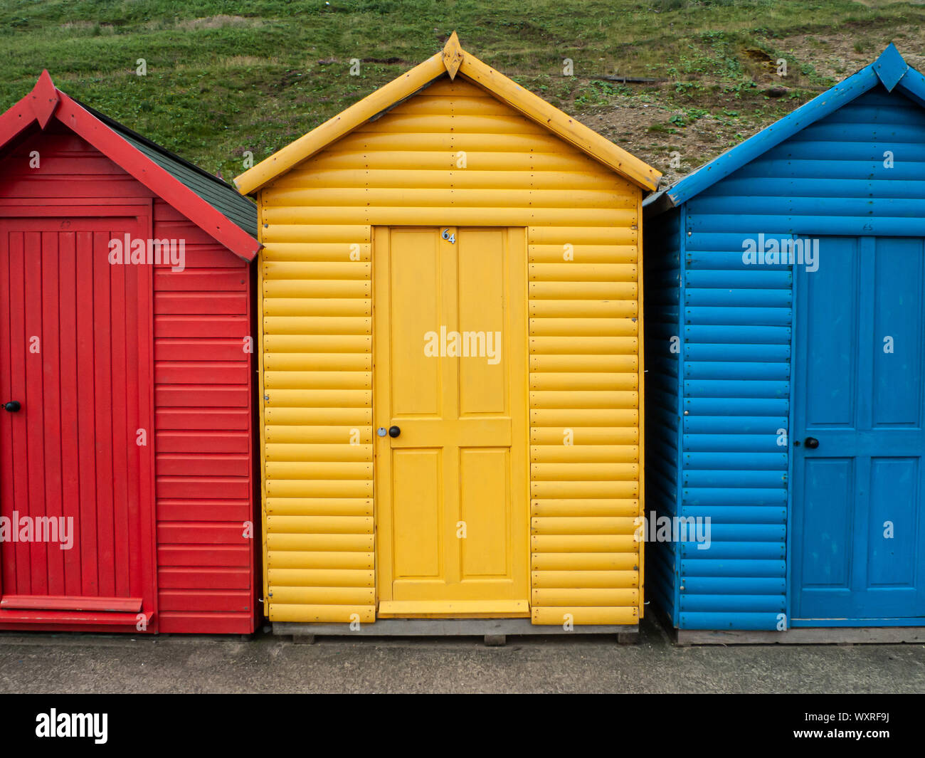 Yellow beach hut between an red and blue beach hut, Whitby Stock Photo ...