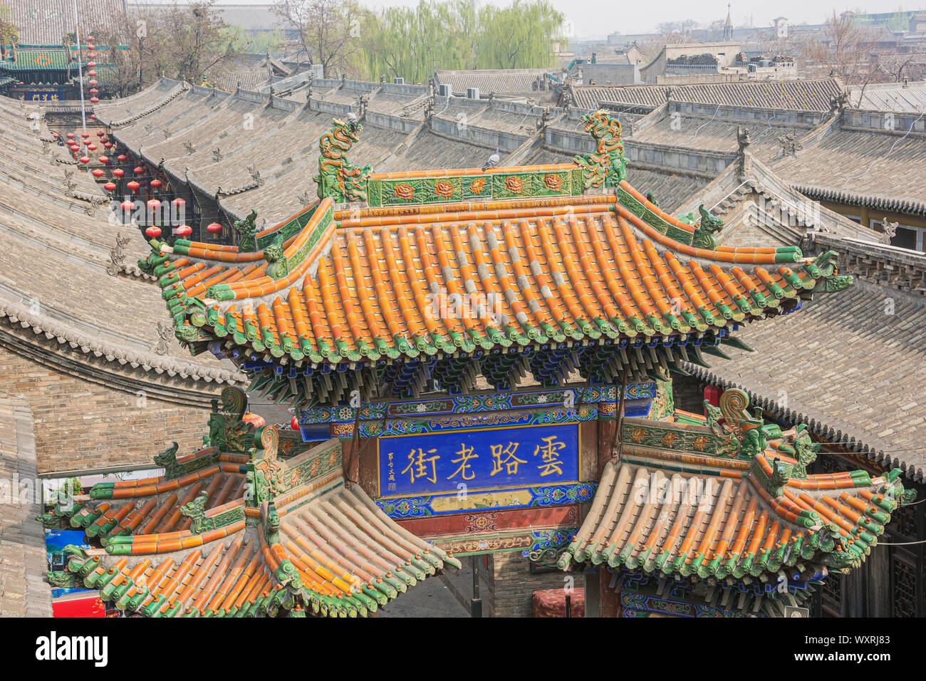 A colored tiled roof of a city gate in Pingyao seen from the city wall ...