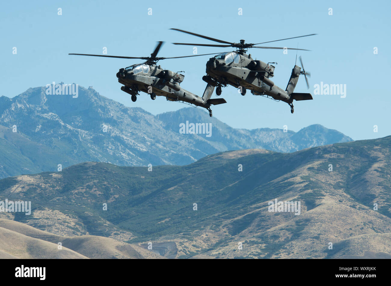 Two AH-64 Apache Longbow attack helicopters fly over Tarbet field ...