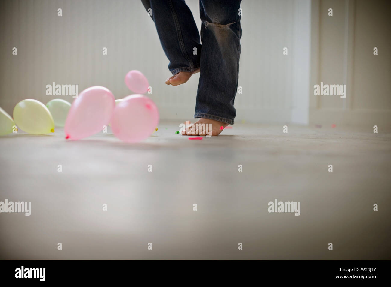 Bare feet popping balloons inside a room Stock Photo - Alamy