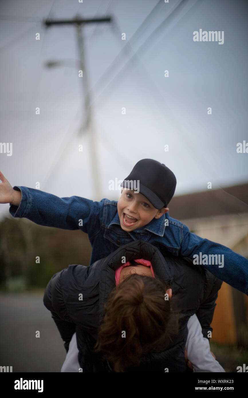 Young boy getting a piggyback ride from his older sister Stock Photo ...