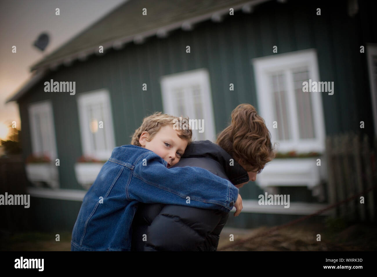 Portrait of a young boy getting a piggyback ride from his older sister ...