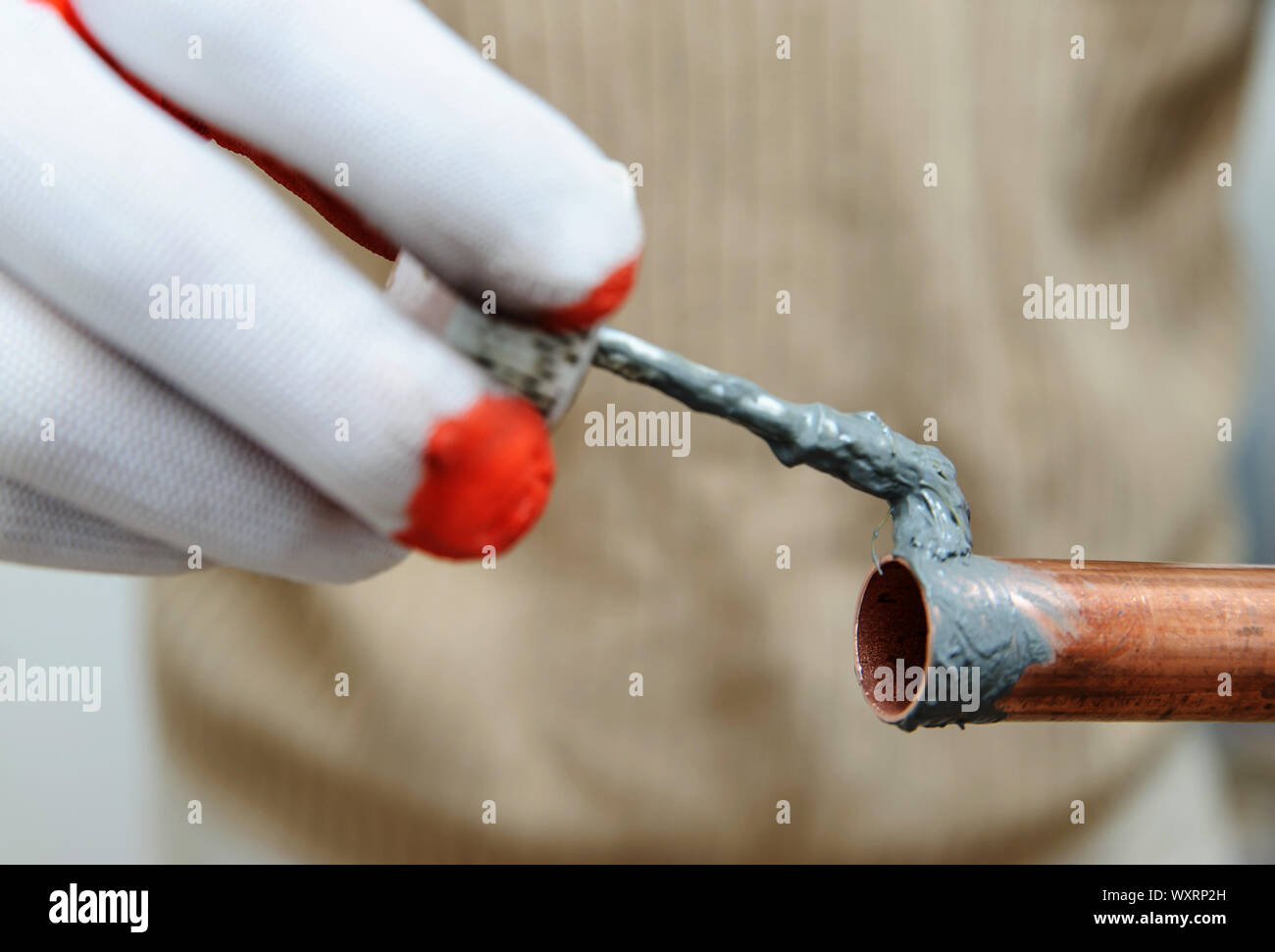 A worker is applying flux to the outside of the copper tube Stock Photo ...