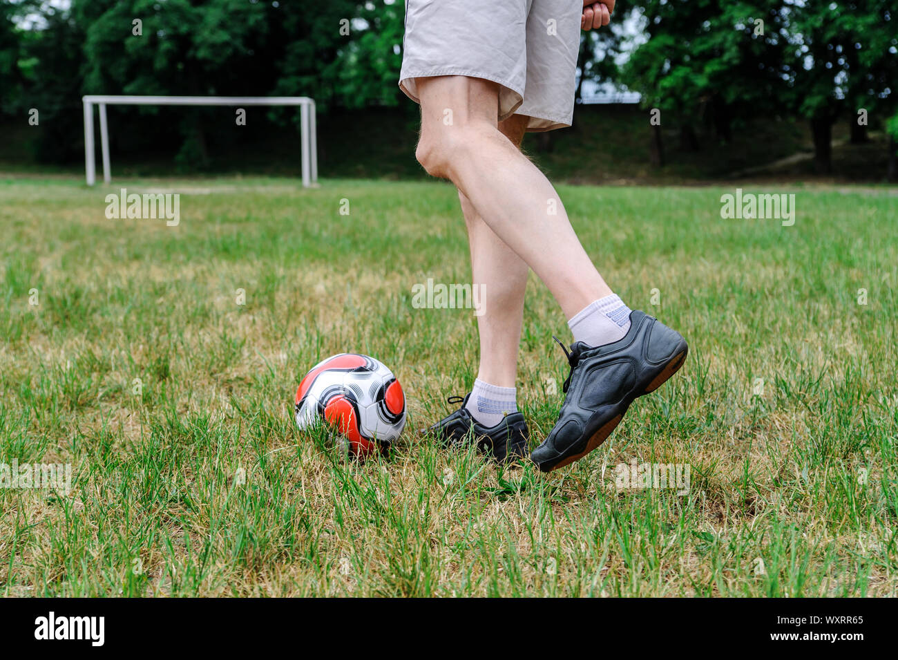Football game. A man out of a swing strikes a ball Stock Photo - Alamy