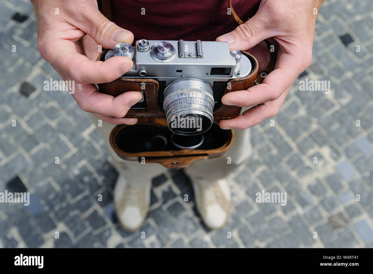 A man is holding a vintage camera. With one hand it is changing the ...