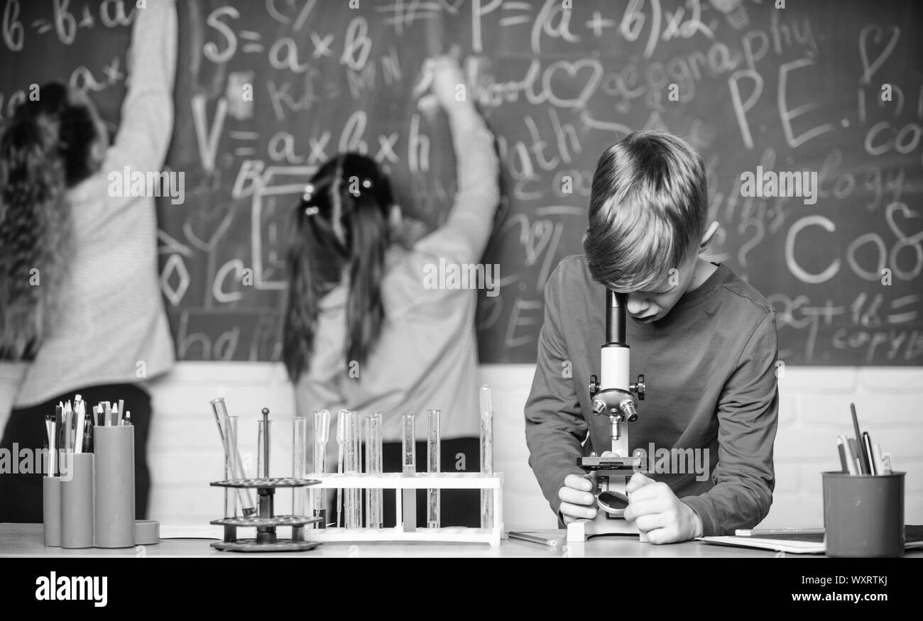 Doing research. Little kids learning chemistry in school lab. Little ...