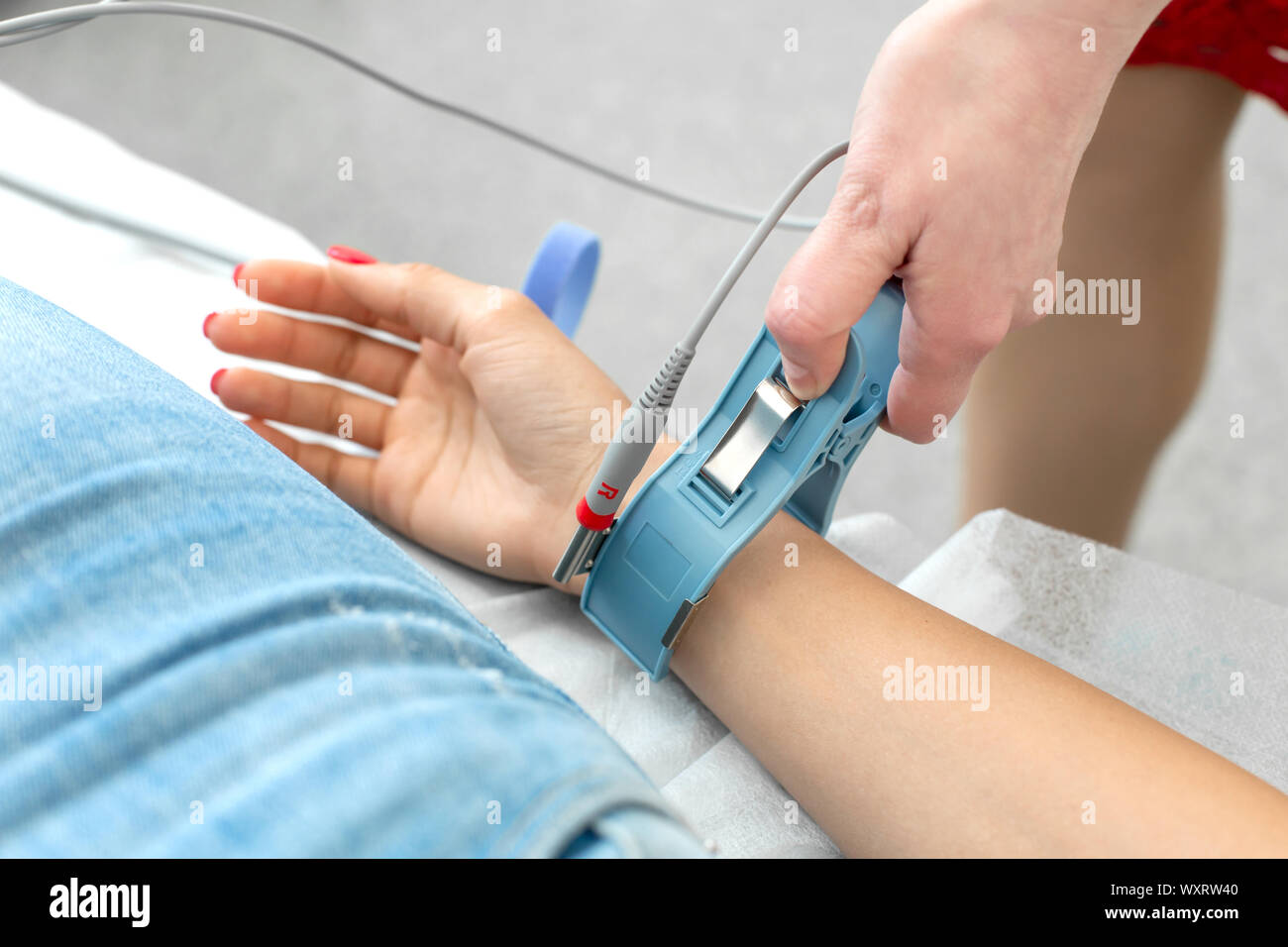 The therapist connects the electrocardiograph sensors to the patient's ...