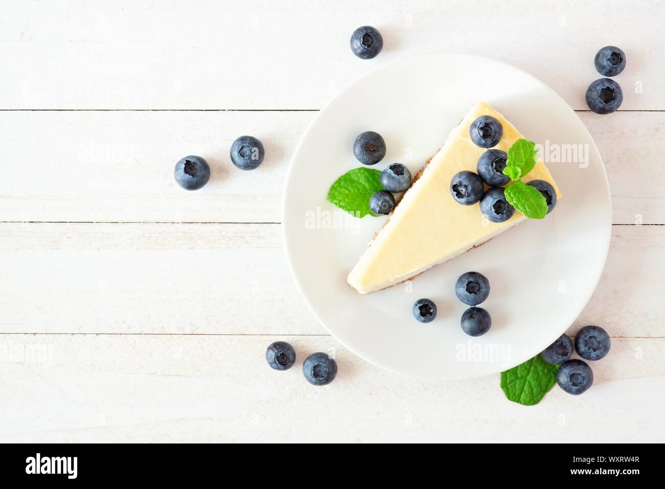 Slice of cheesecake with blueberries. Top view scene over a bright ...