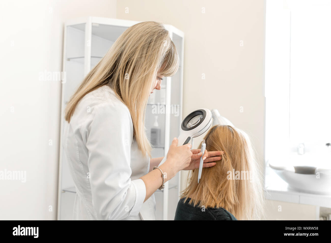 The doctor trichologist dermatologist examines the scalp and the ...