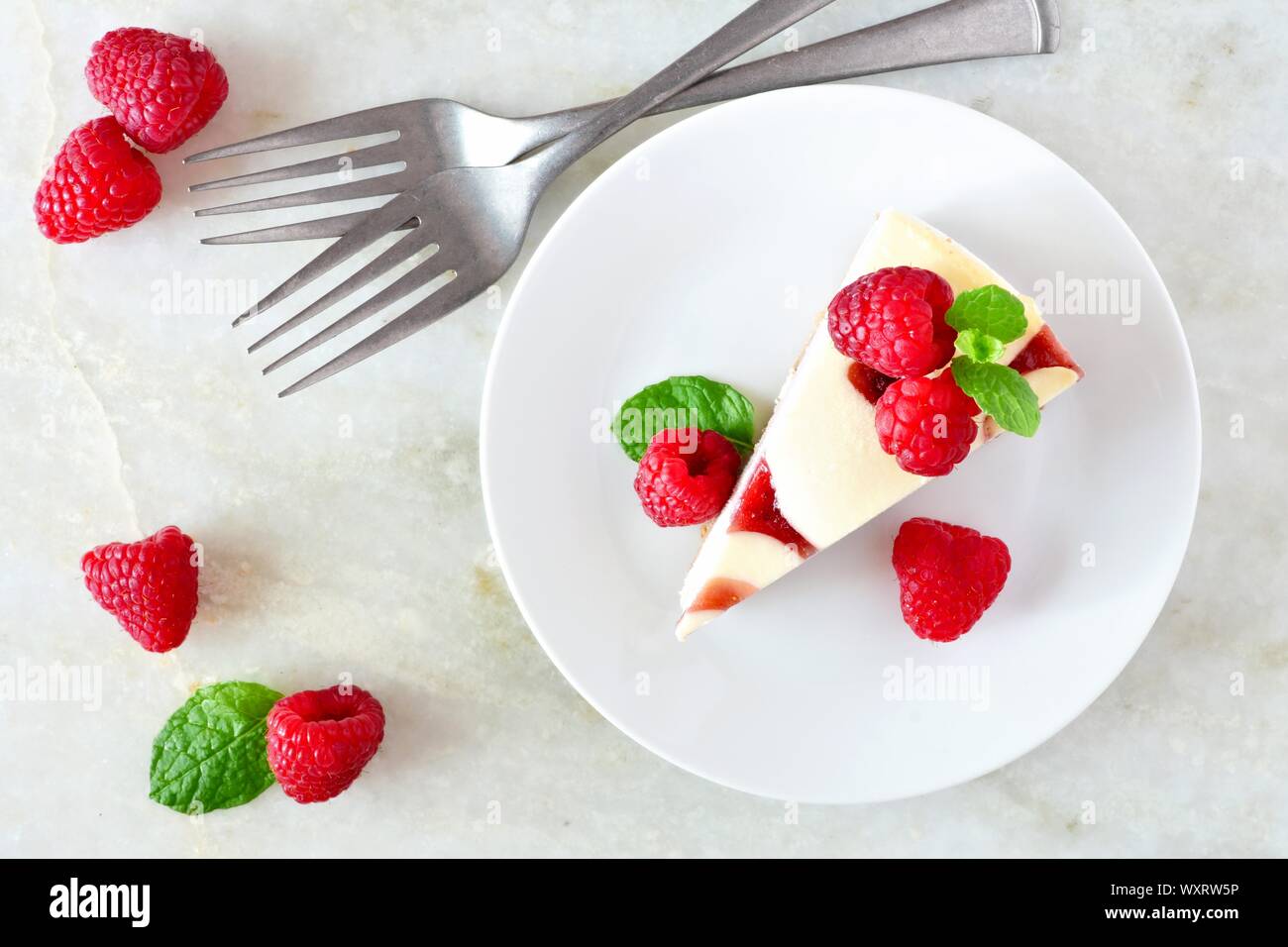 Slice of raspberry cheesecake, top view scene over a bright background ...