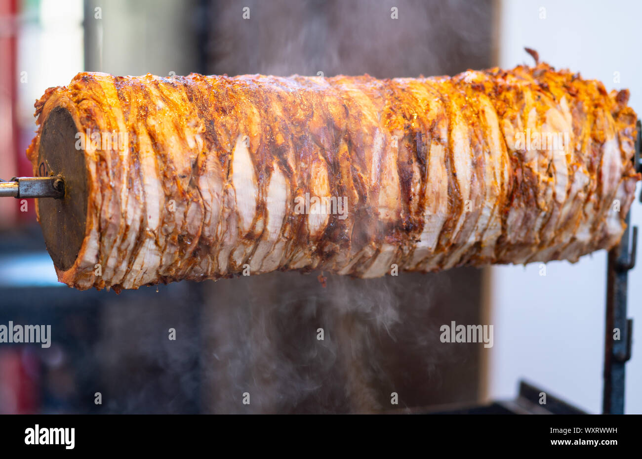 Traditional spicy seasoned Doner kebab roasting on a rotisserie or spit ...