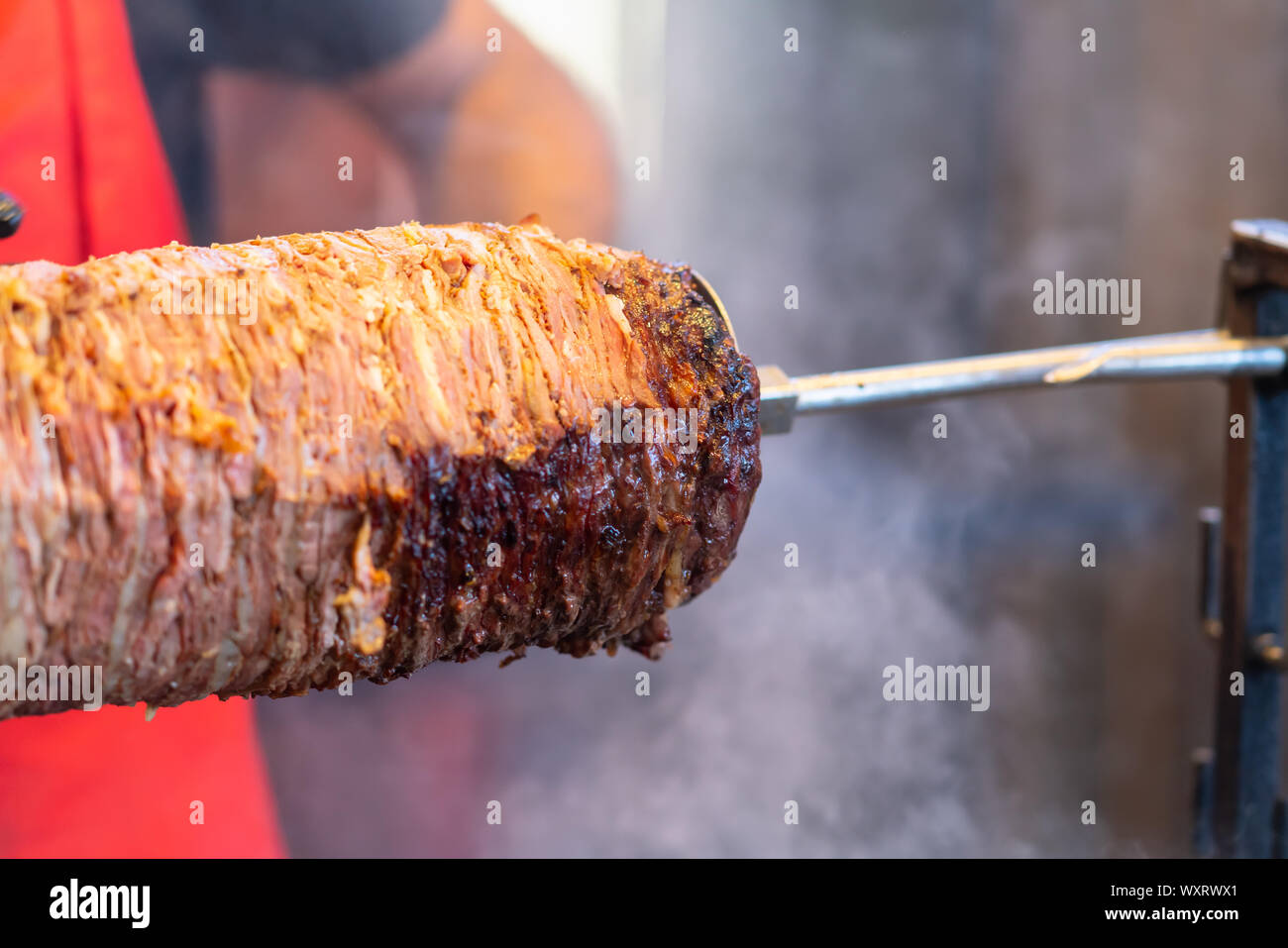 Close up on the seasoned spicy meat of a doner kebab roasting on a ...
