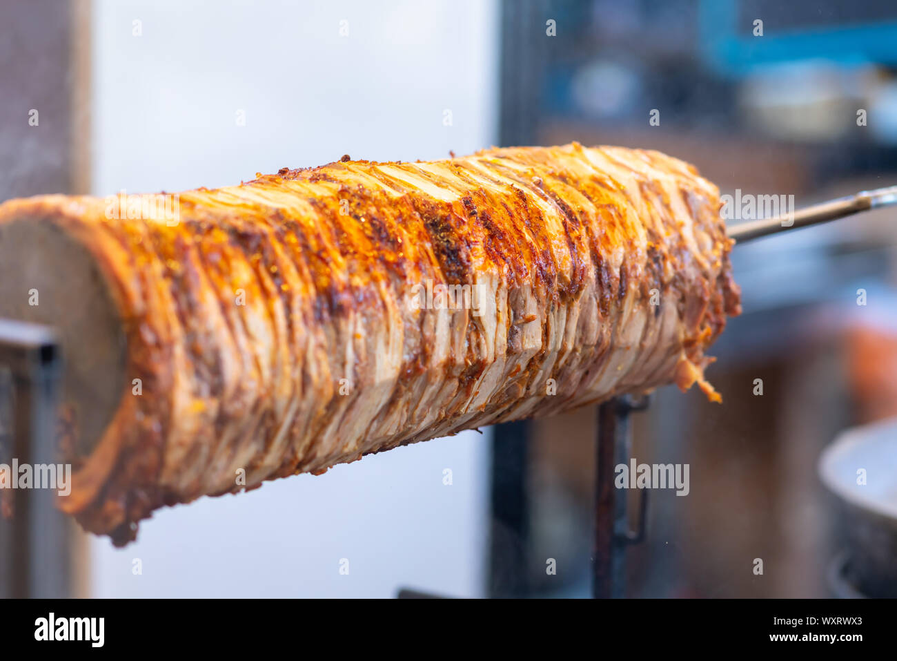 Delicious spicy doner kebab grilling on a rotisserie outdoors at a ...