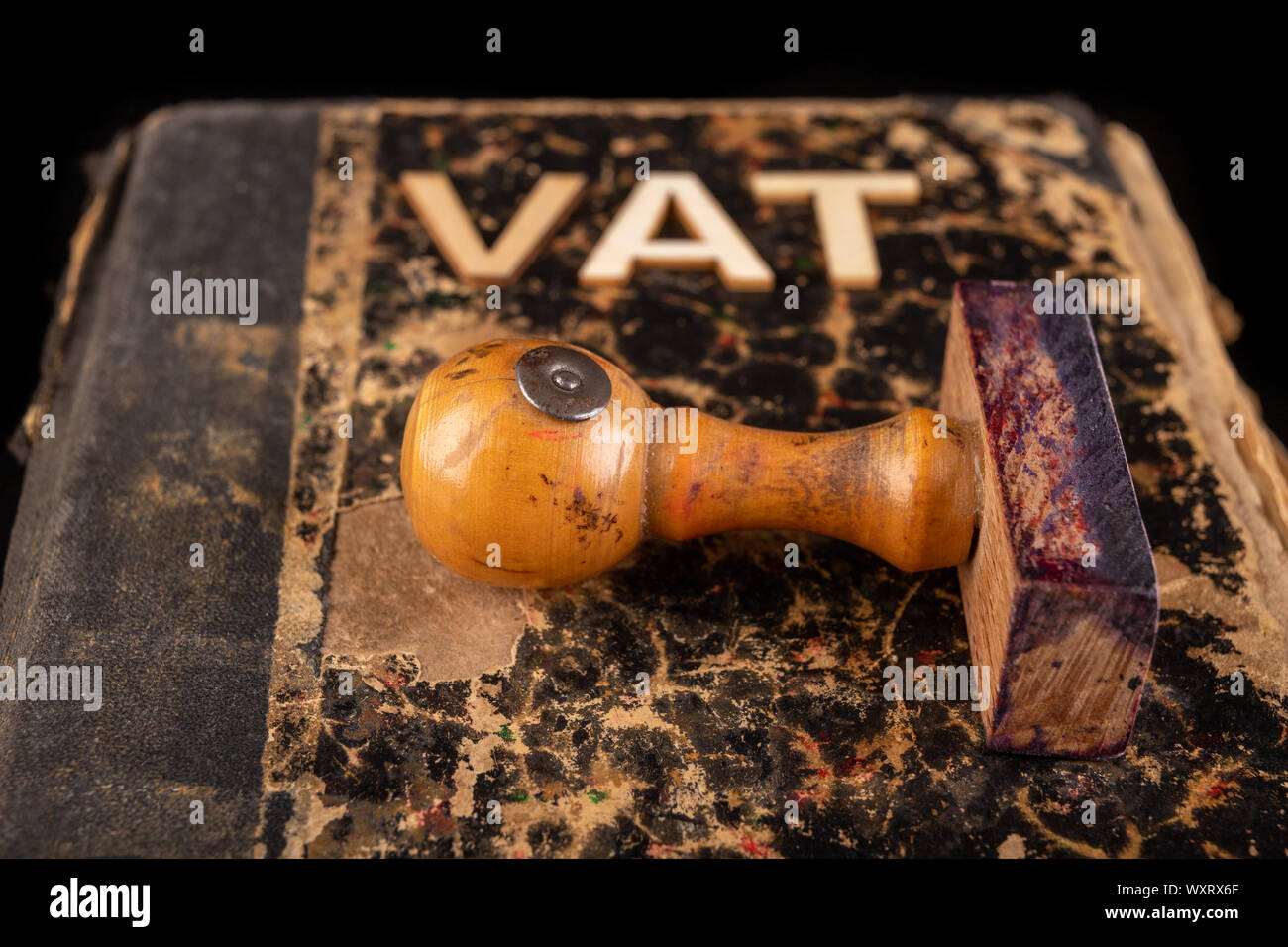 Vat inscription on the old book and stamp. Office accessories on a dark ...