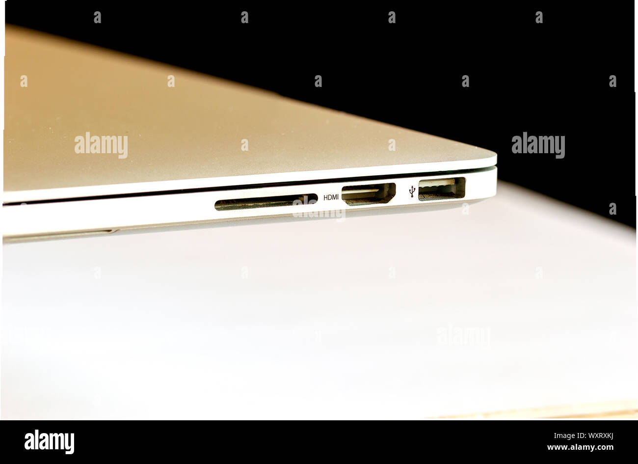 Side of Modern Laptop Silver Color in the Shadow on a White Table. Port ...