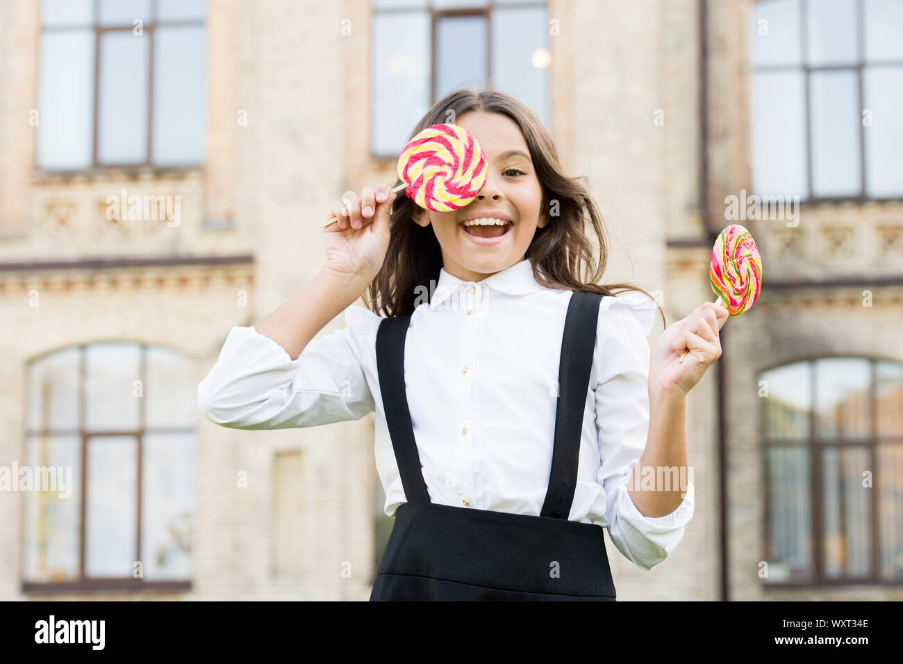 Cheat meal day. Happy kid with sweet candy. Kid child holding lollipops ...