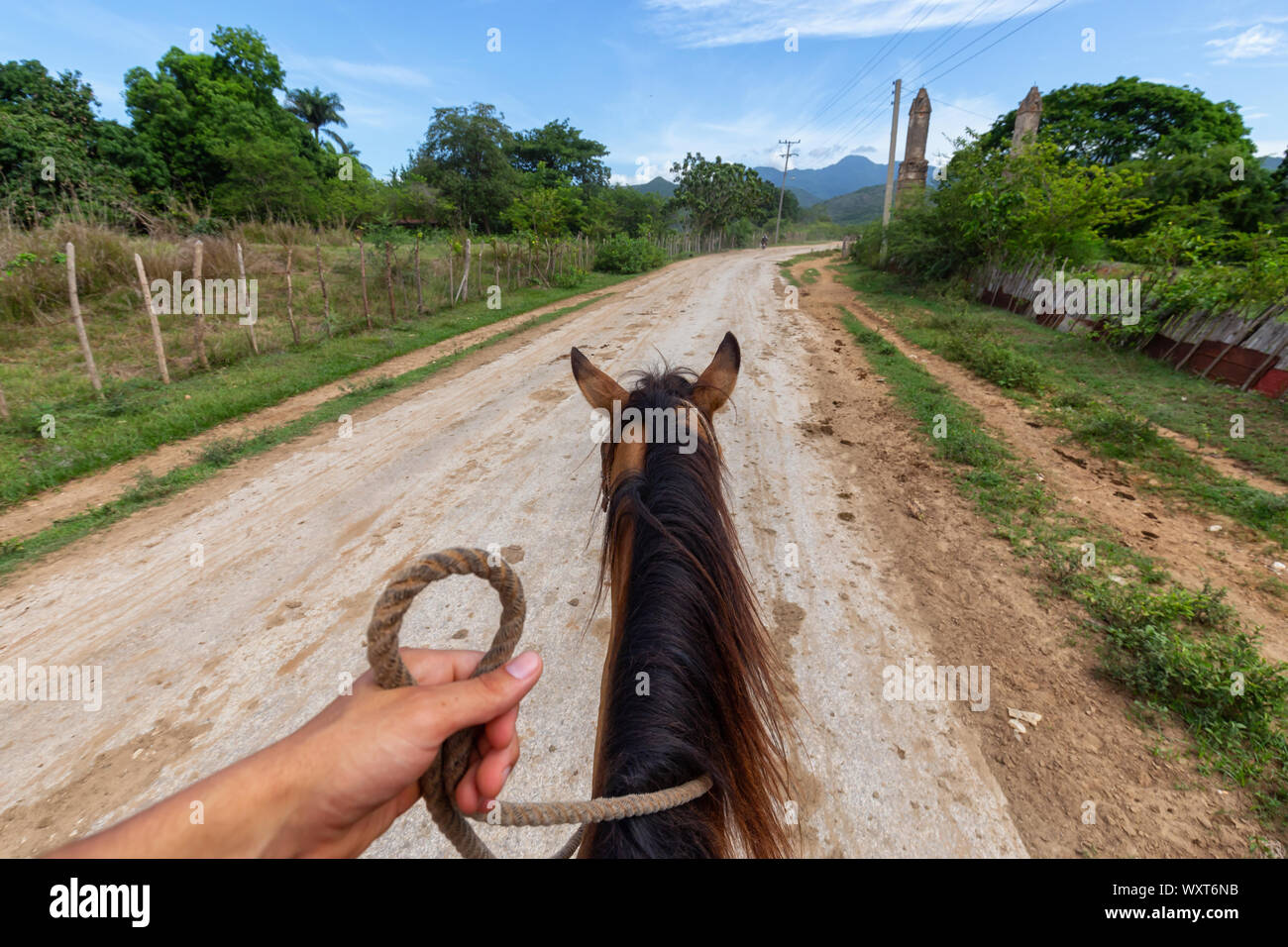 Horseback Riding on a dirty trail in the country side near a small ...