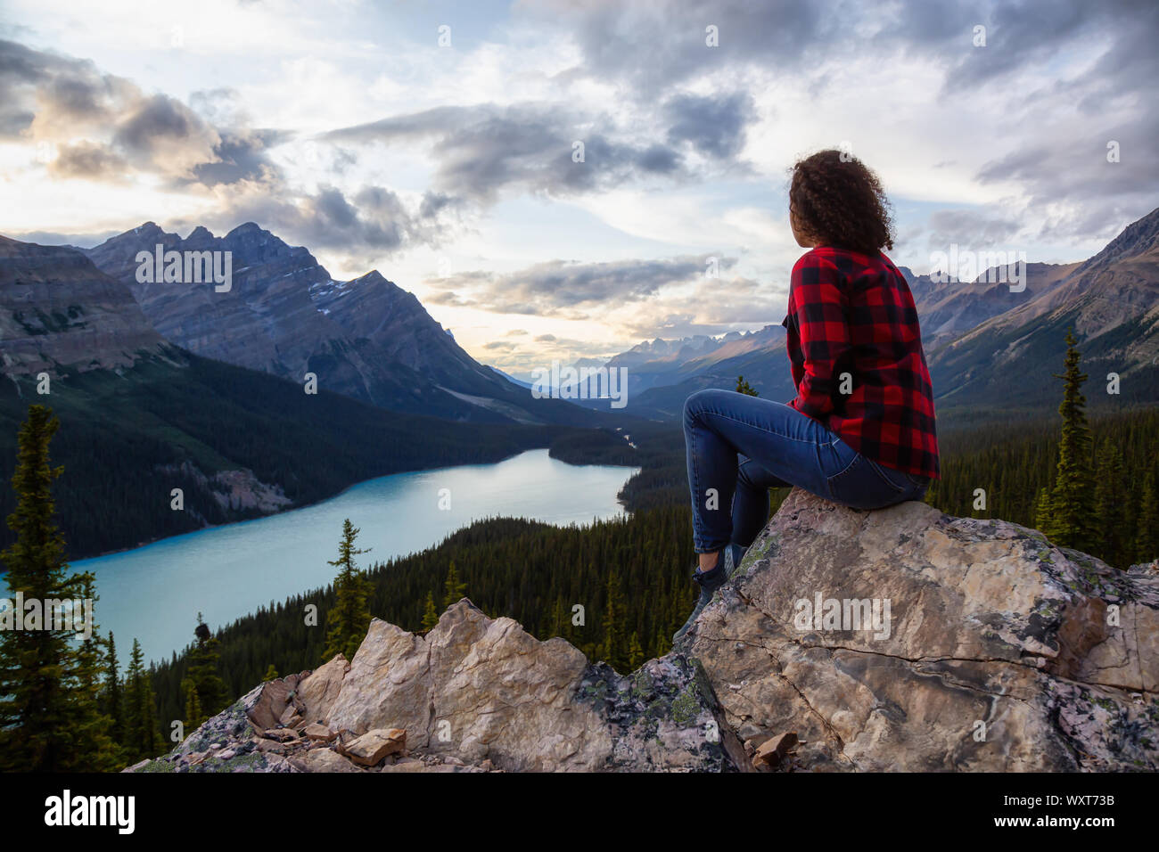 Adventurous girl on the edge of a cliff overlooking the beautiful ...