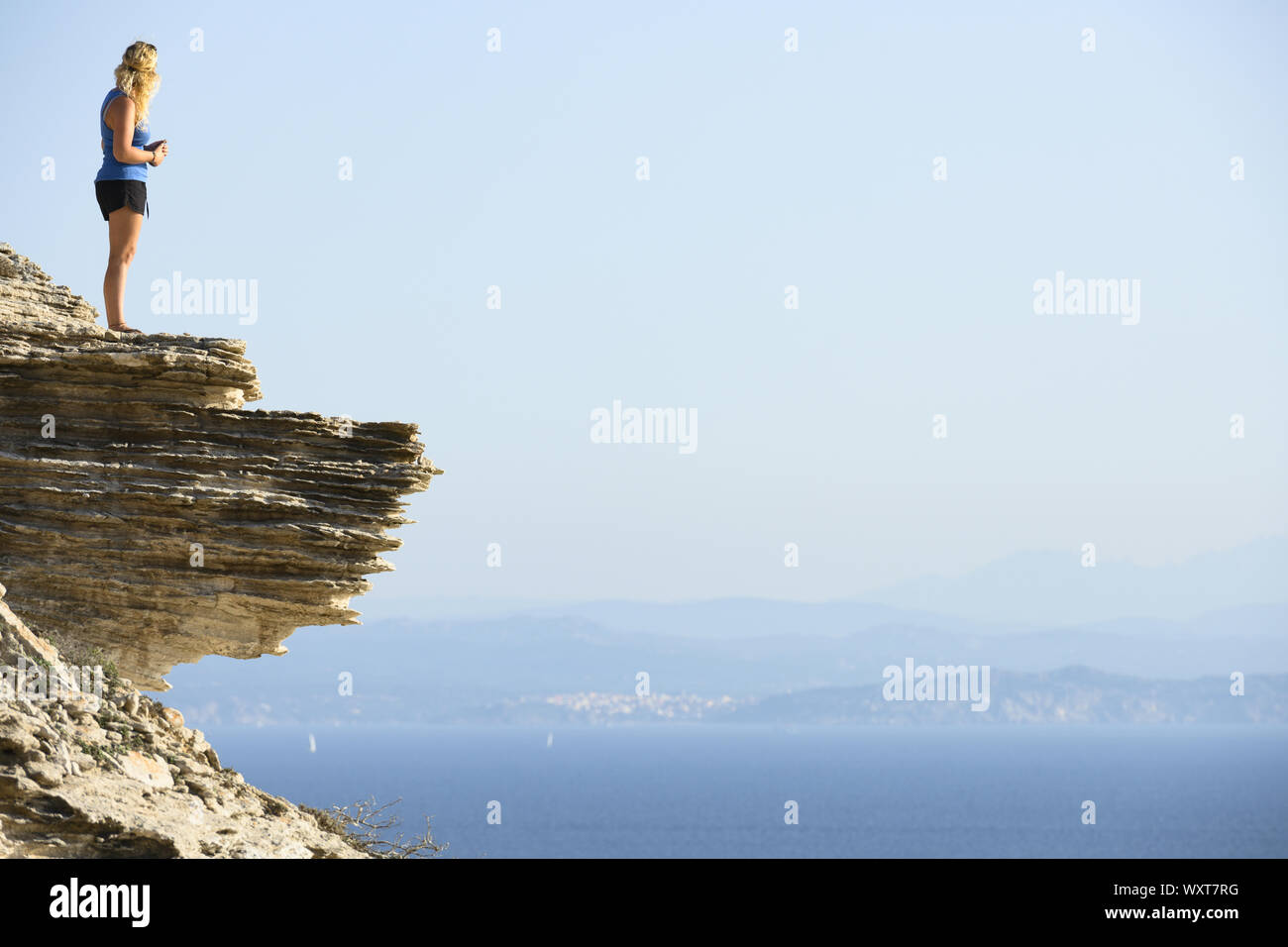 Stunning view of an unidentified blond girl on top of a limestone cliff ...