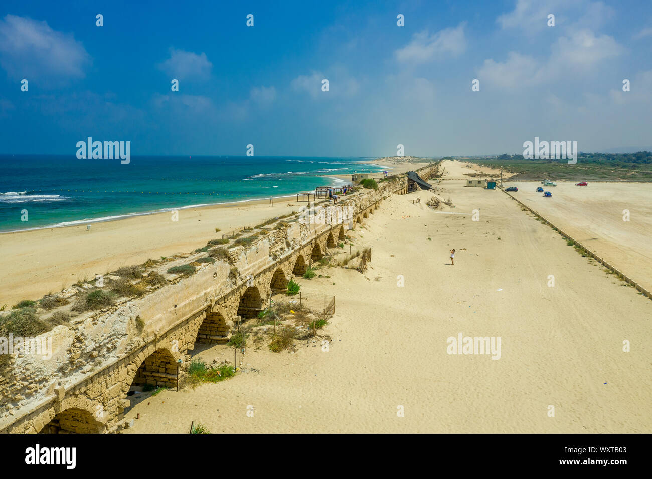 Ruins of the Roman aqueduct arches on the beach of Caesarea Israel with ...