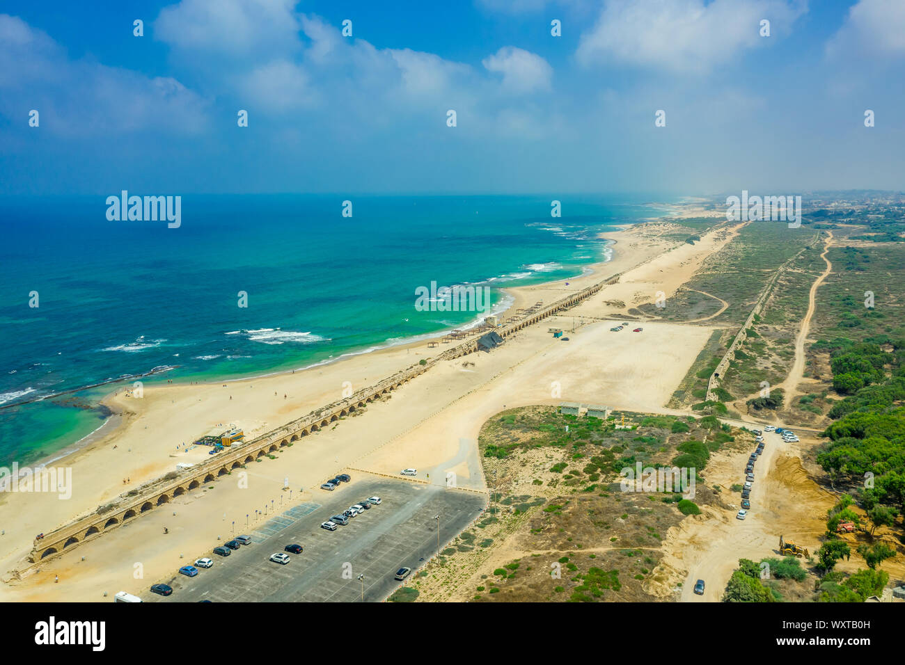 Ruins of the Roman aqueduct arches on the beach of Caesarea Israel with ...