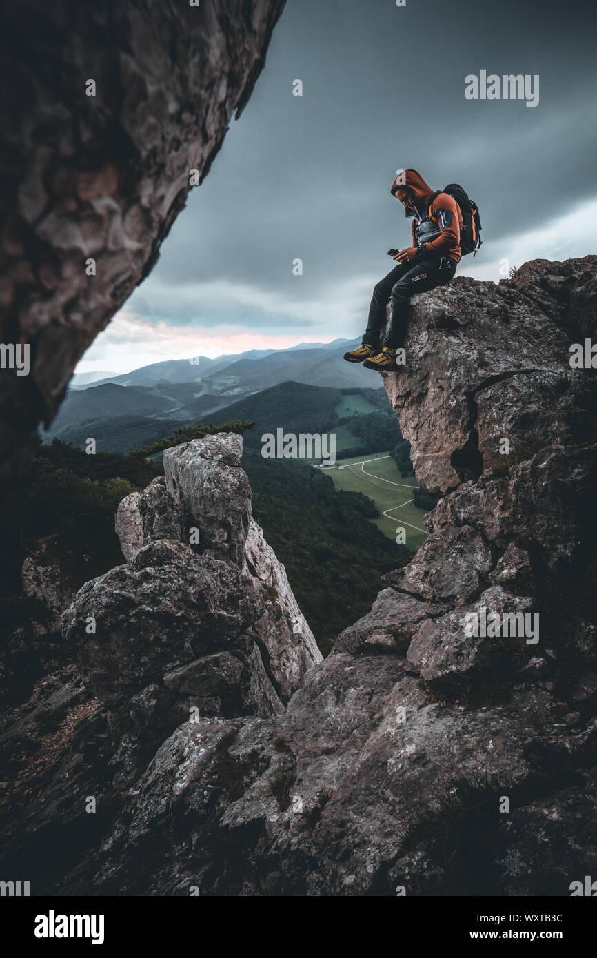 Hiker sits on a mountain cliff on the peilstein in austria Stock Photo ...