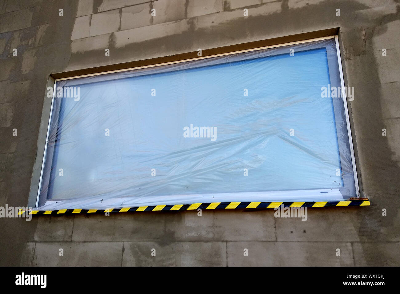 Window of a house under construction covered with protective plastic ...