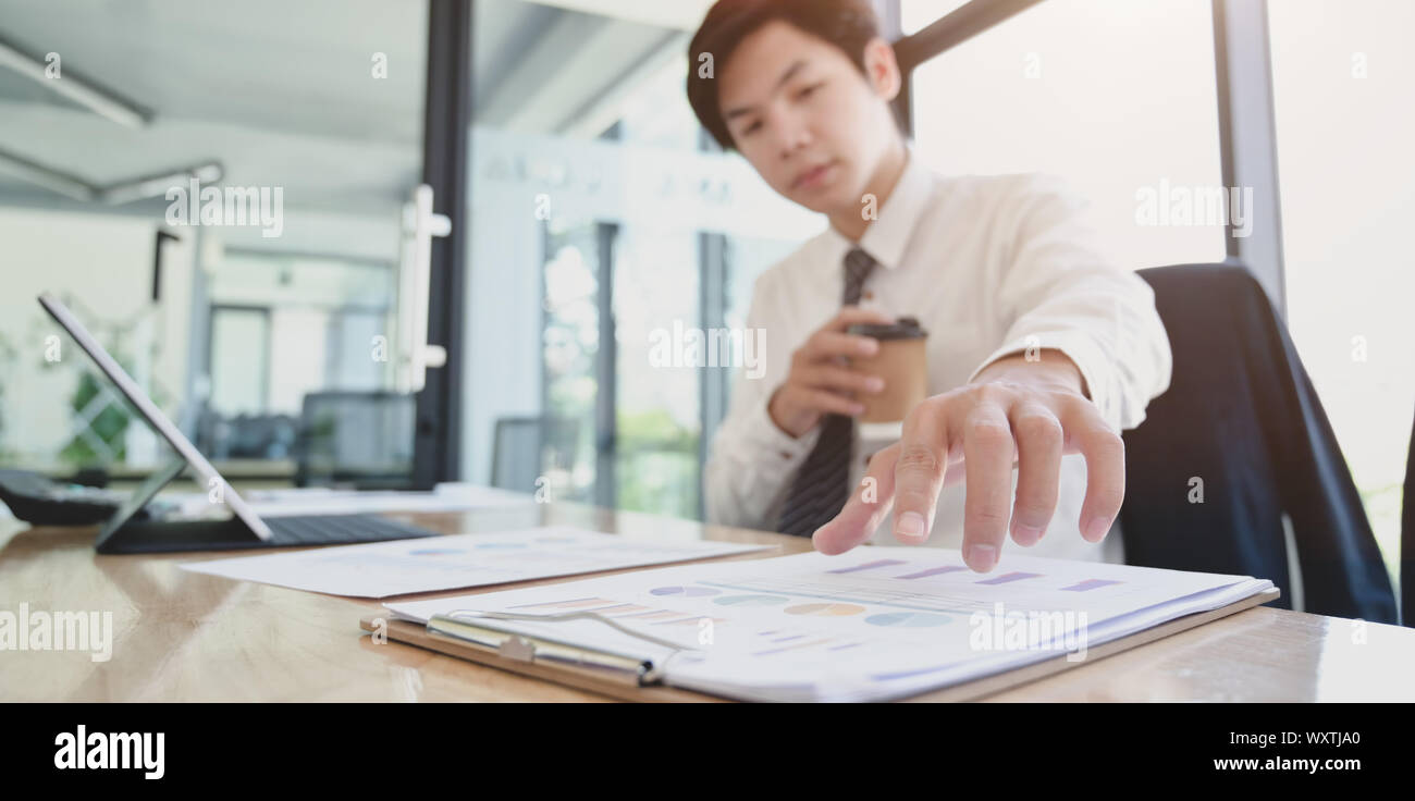 Young professional male accountant analysing and reviewing expenditures ...