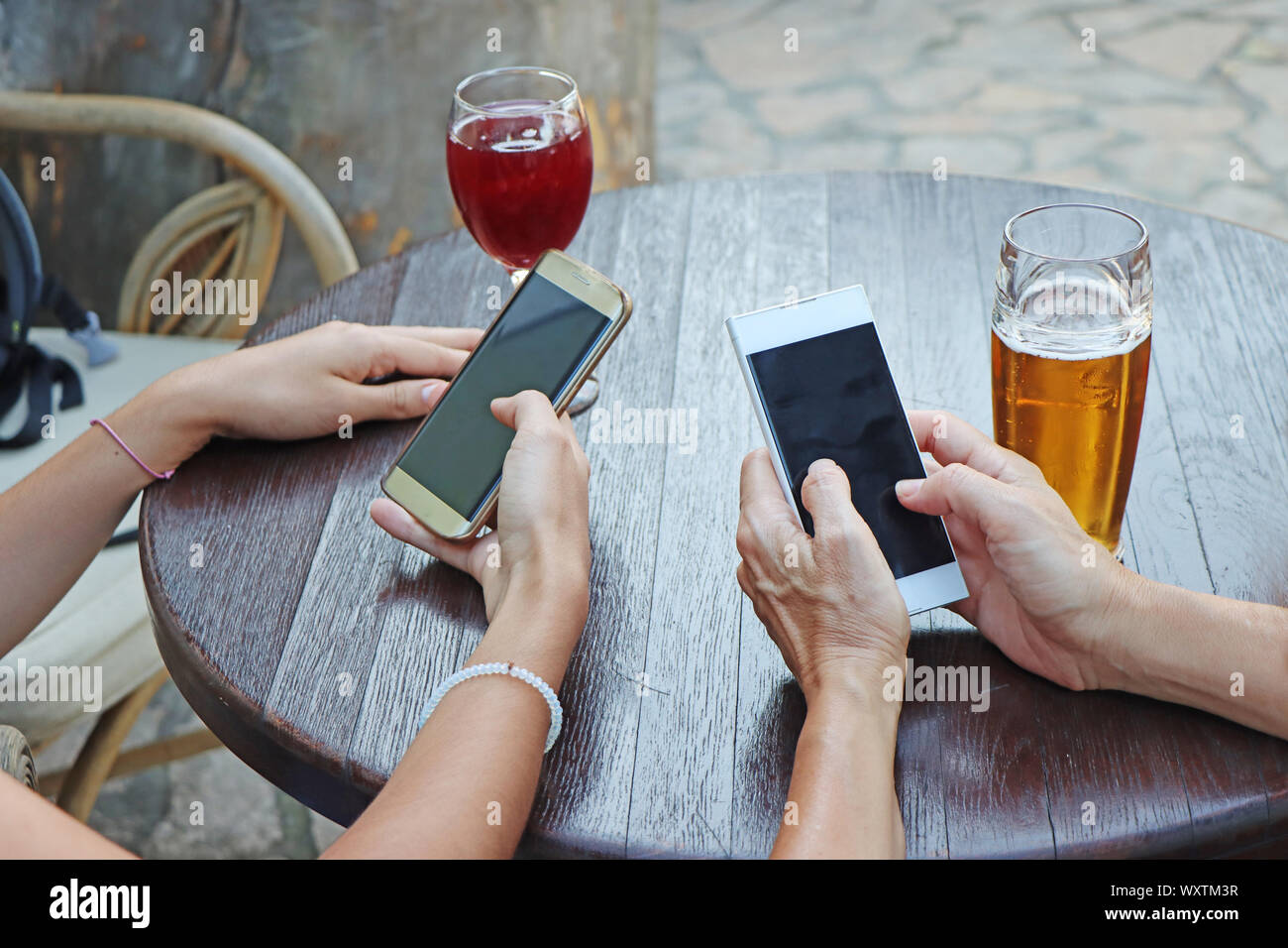 Two young girls watching smart mobile phones Stock Photo - Alamy