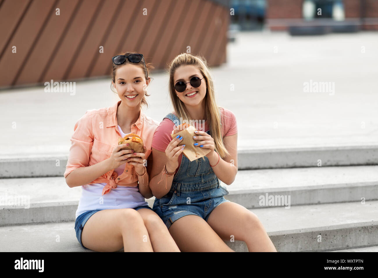 leisure, fast food and friendship concept - happy smiling teenage girls ...