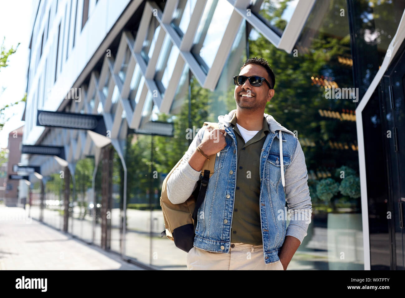 travel, tourism and lifestyle concept - smiling indian man with ...