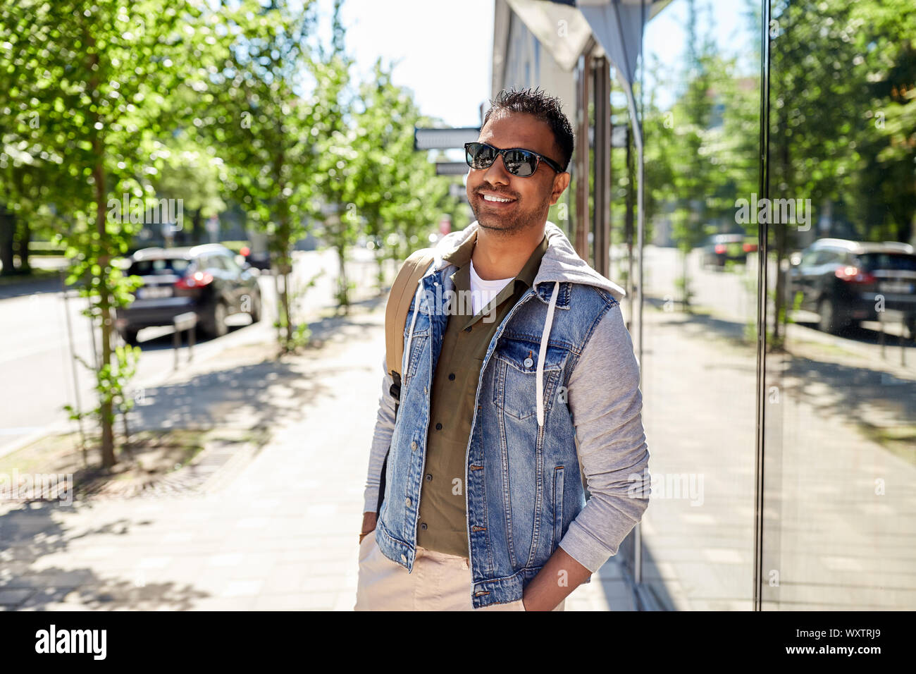 travel, tourism and lifestyle concept - smiling indian man with ...