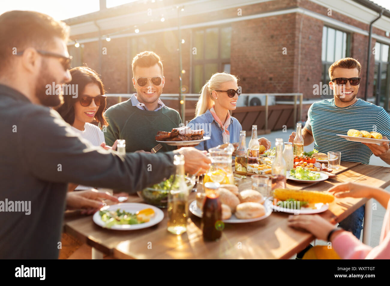 leisure and people concept - happy friends eating and drinking at ...