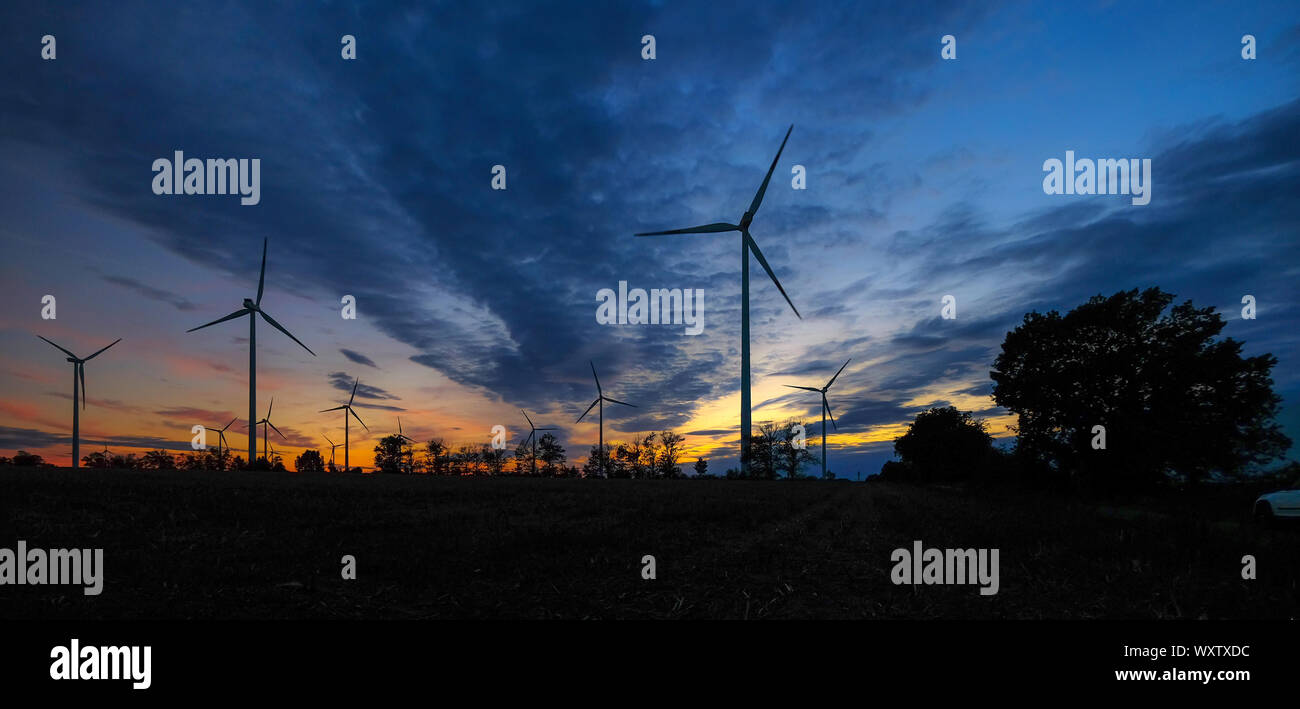 Sunset and windmills on a summer evening Stock Photo - Alamy