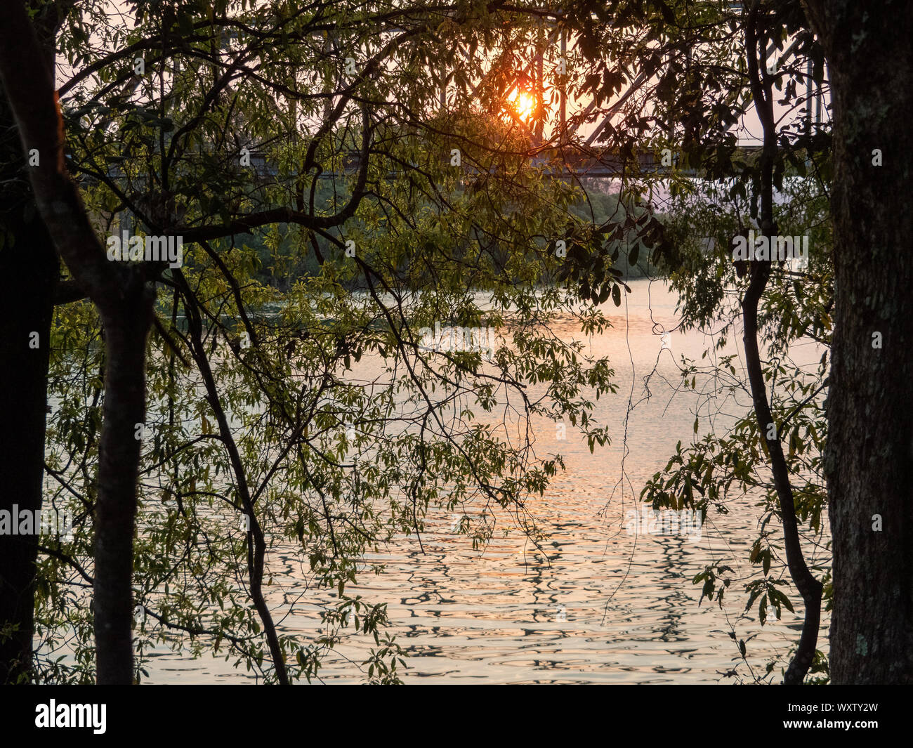 sunset over river behind railroad bridge Stock Photo - Alamy