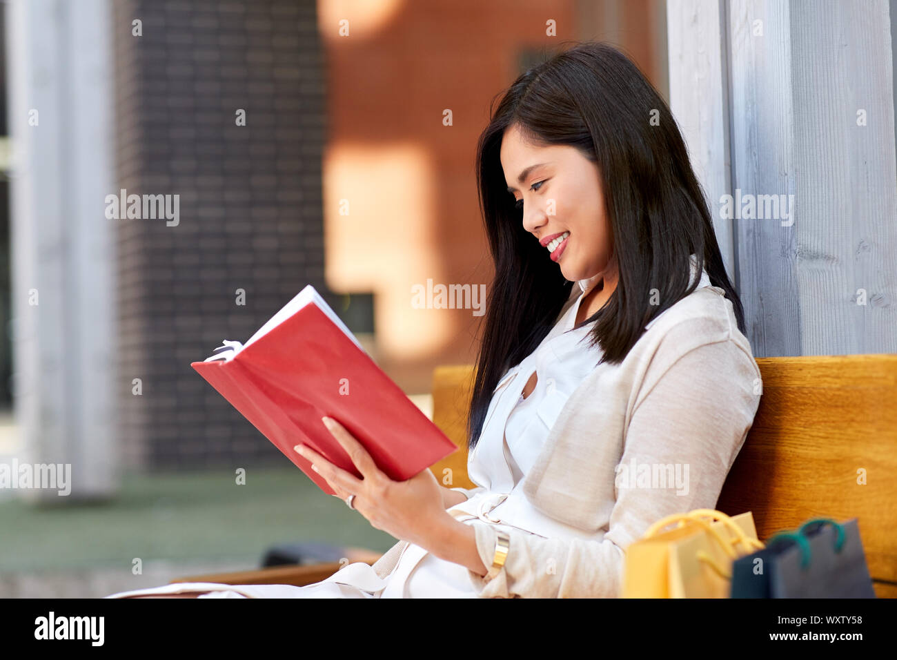 leisure, literature and people concept - smiling young asian woman ...