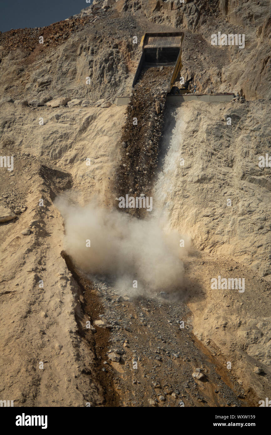 Dumper unload stones from mine to dump Stock Photo - Alamy