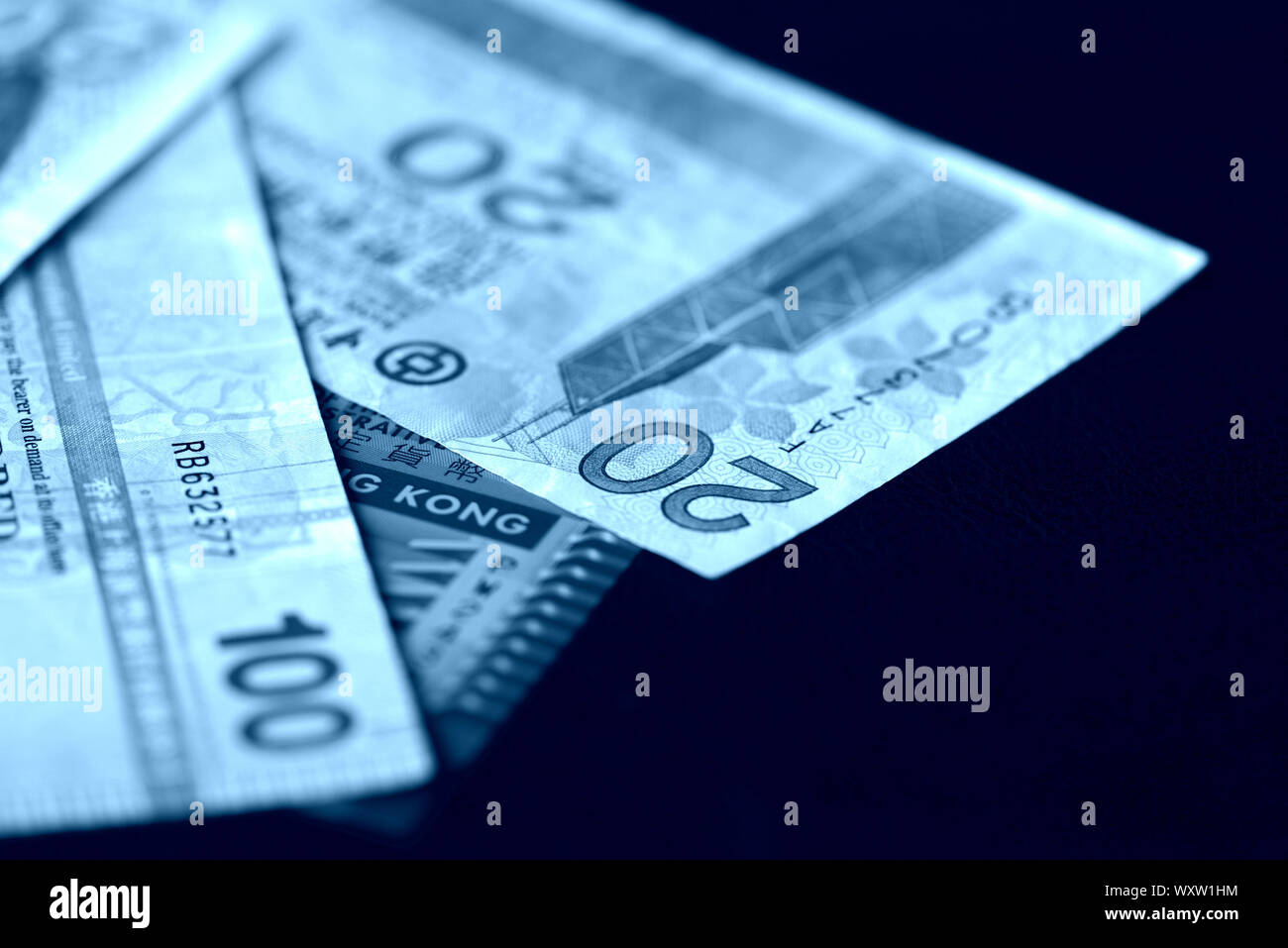 Hong Kong dollars banknotes on a dark background close up. Blue color ...