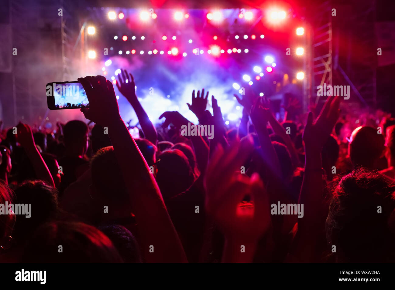 People taking photographs with touch smart phone during a music ...