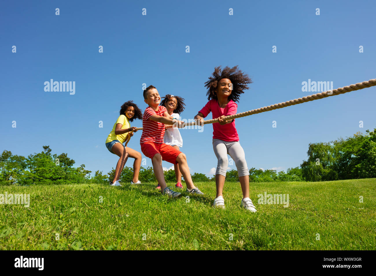 Kids pull rope - a competitive fun game in park Stock Photo - Alamy