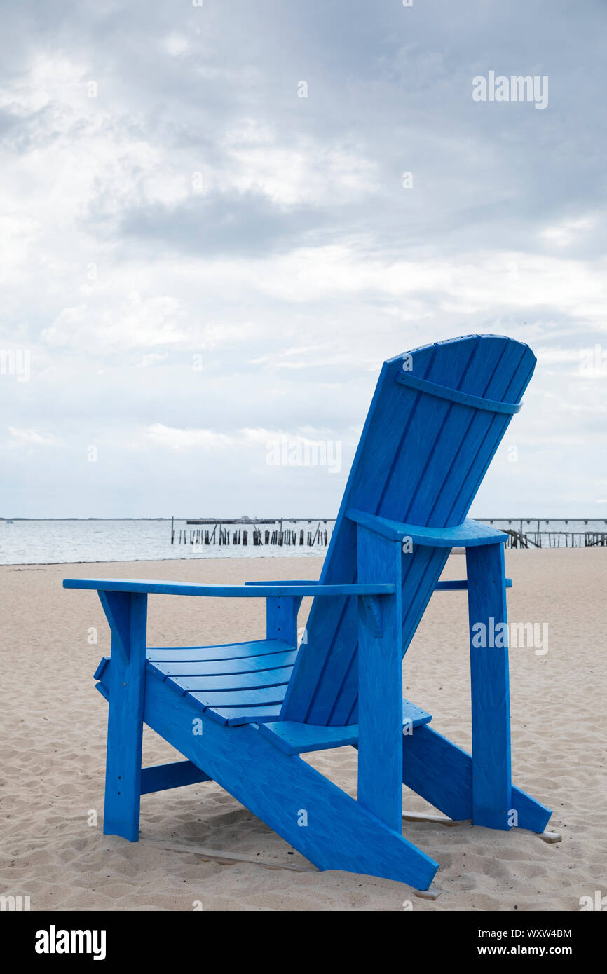 Oversize large Adirondack chair in bright blue colour on the beach ...