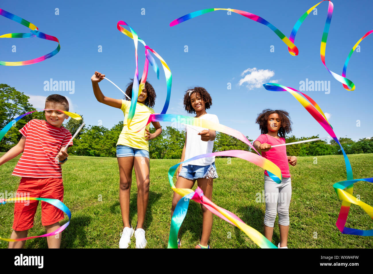Children wave colorful ribbons in park together Stock Photo - Alamy