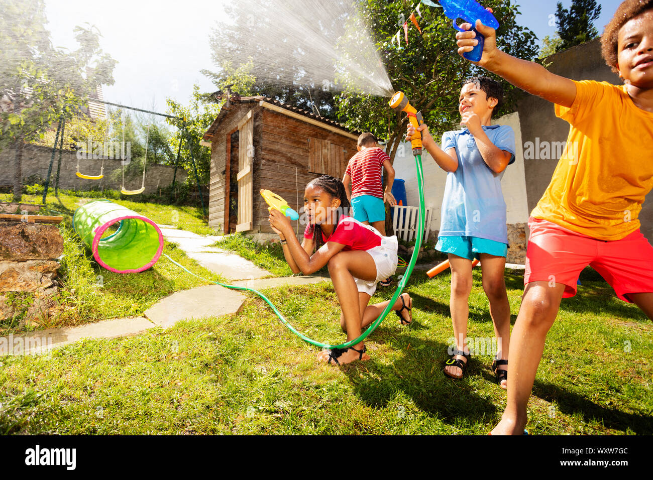 Children In the middle of water gun fight fun Stock Photo - Alamy